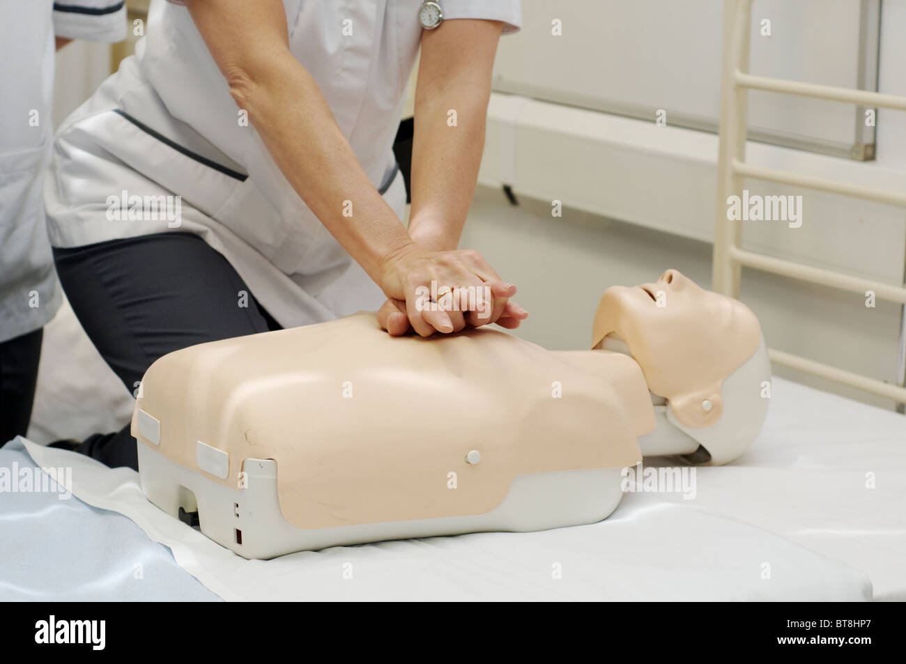 A student nurse learning life saving resuscitation on a dummy patient ...