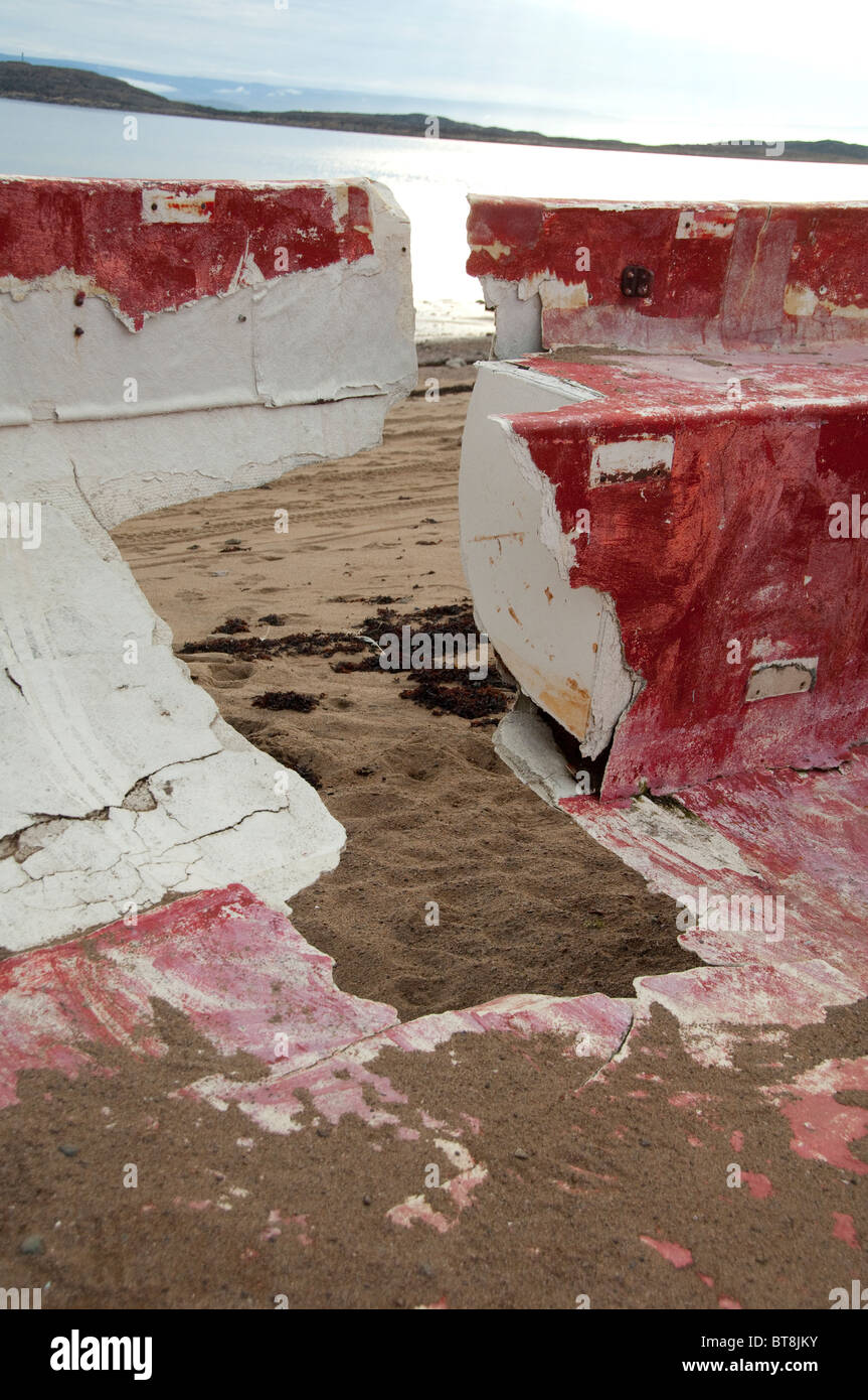 Arctic Canada, Nunavut, Baffin Island, Iqaluit (aka Frobisher Bay). Boat with hole on beach ...