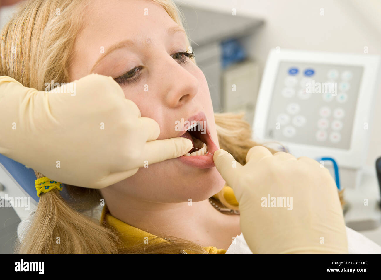 Dental nurse cleaning a patient's teeth with dental floss Stock Photo ...