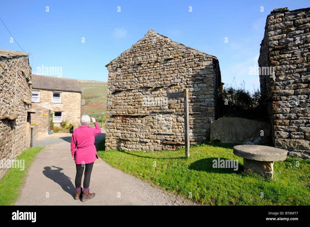 Woman reading Signpost to Gunnerside & Keld Meadow Land in Muker ...
