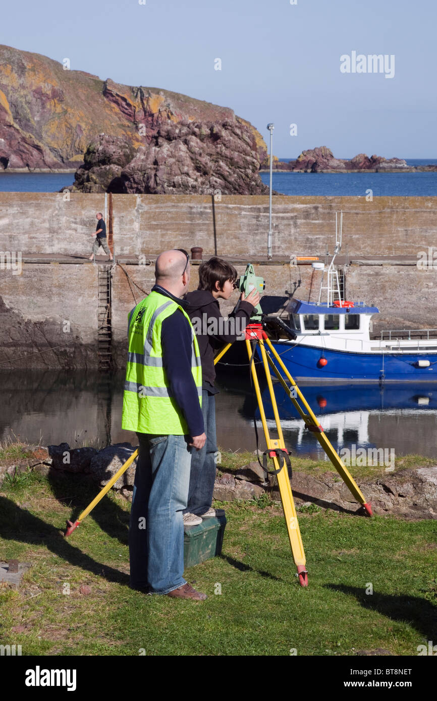 Man teaching a student how to use a Leica theodolite for surveying ...