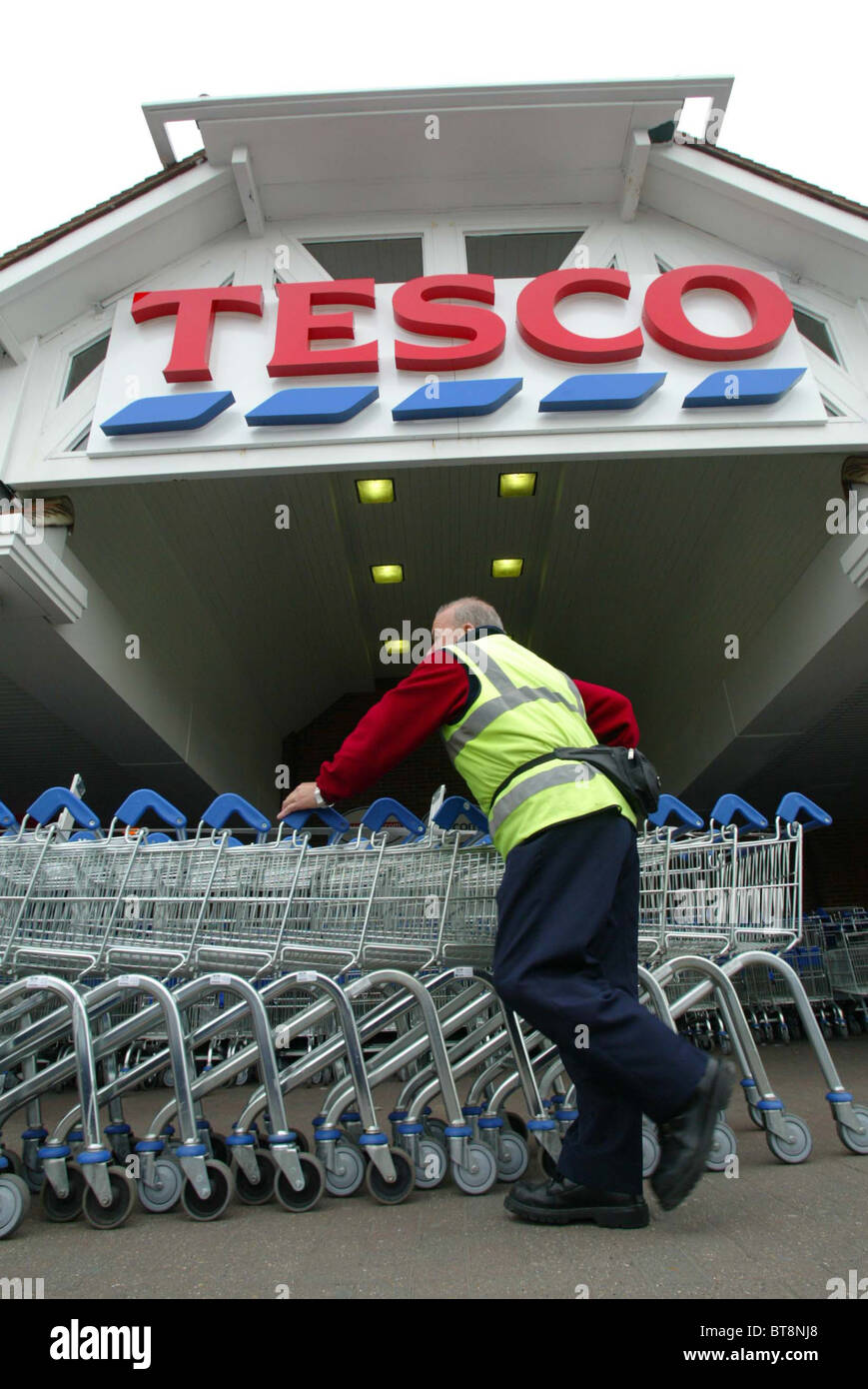 Man collecting shopping trolleys at a Tesco Supermarket. Picture bu ...