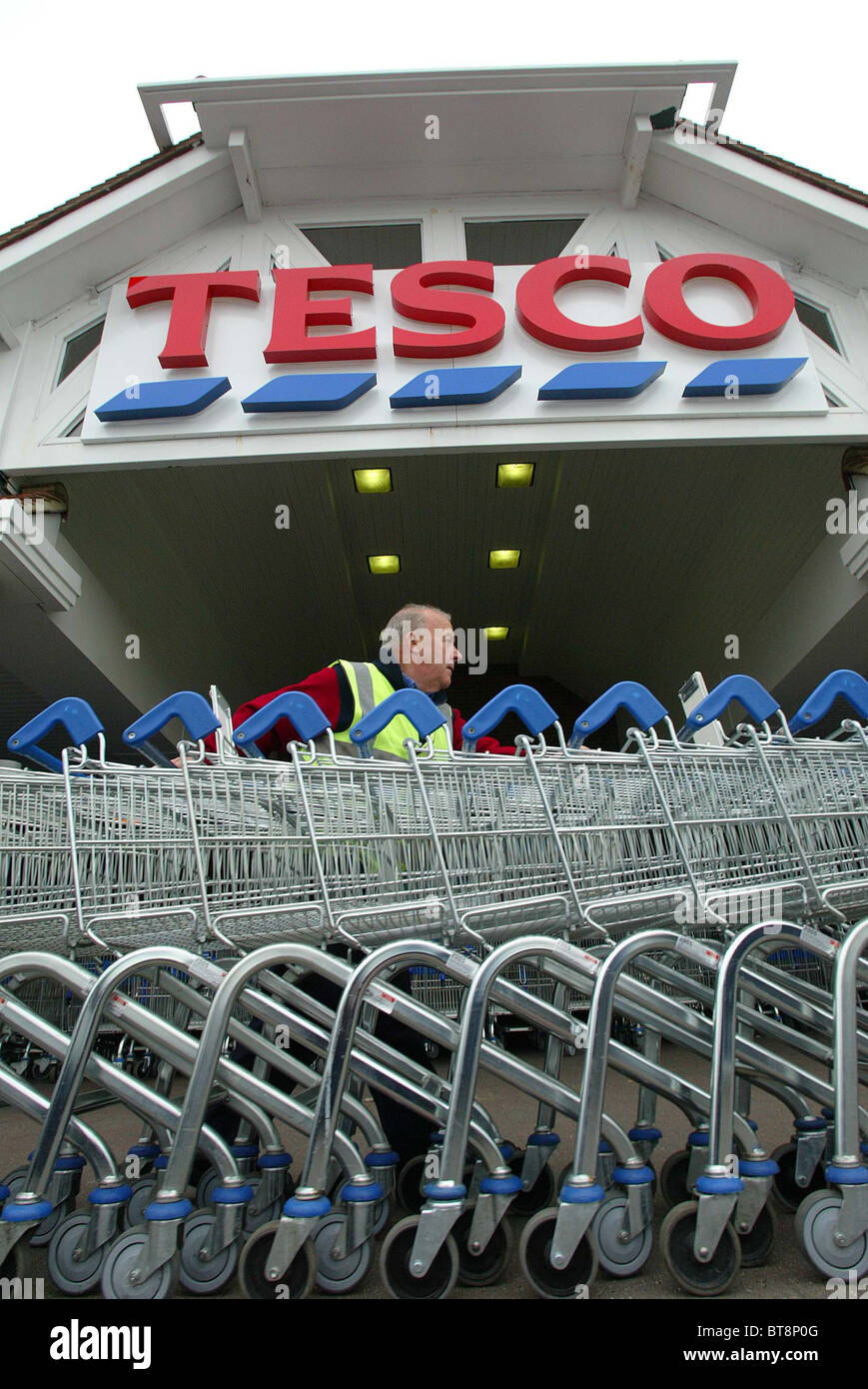 Man collecting shopping trolleys at a Tesco Supermarket. Picture bu ...