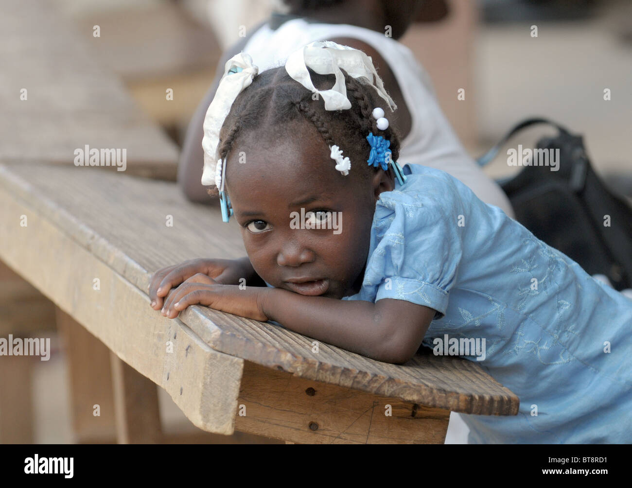 Young Haitian girl leaning on bench Stock Photo - Alamy