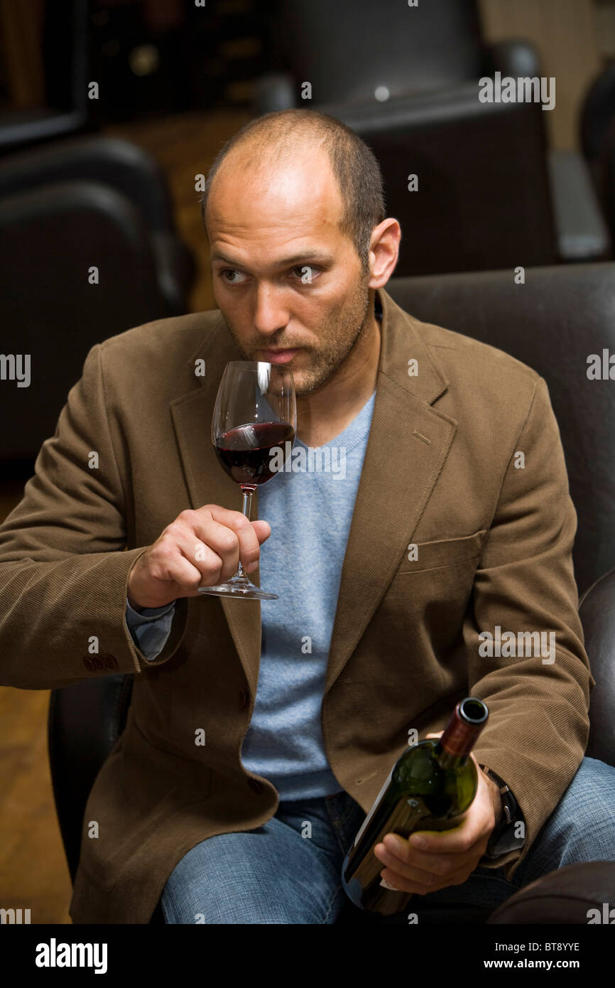 Young man drinking wine Stock Photo - Alamy