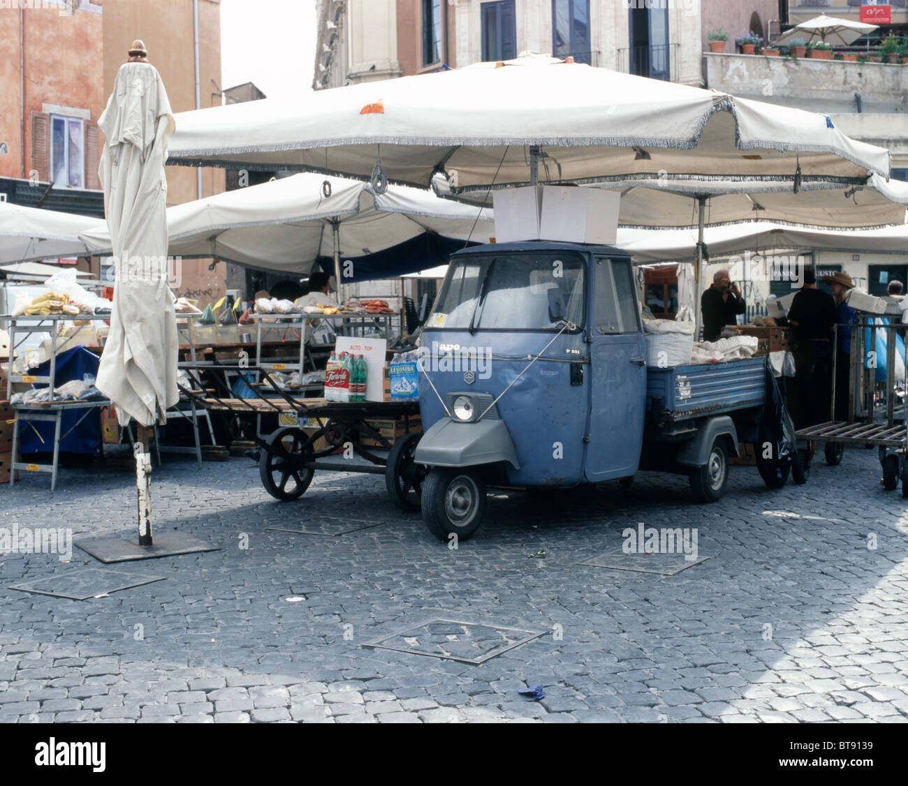 Market stand with umbrellas and a blue Piaggio transporter on Campo dei ...