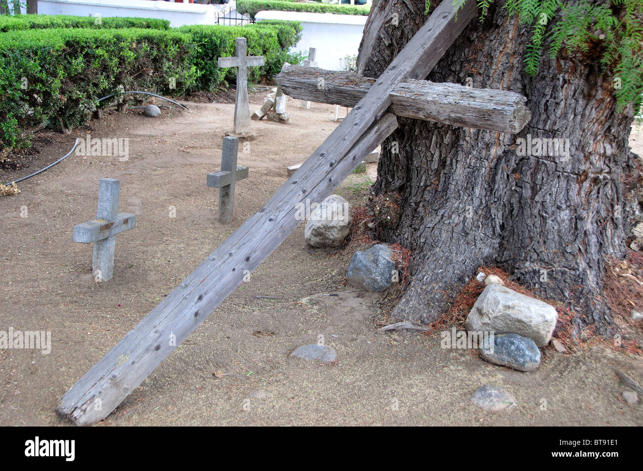Wooden cross leaning against a California pepper tree in an Indian ...
