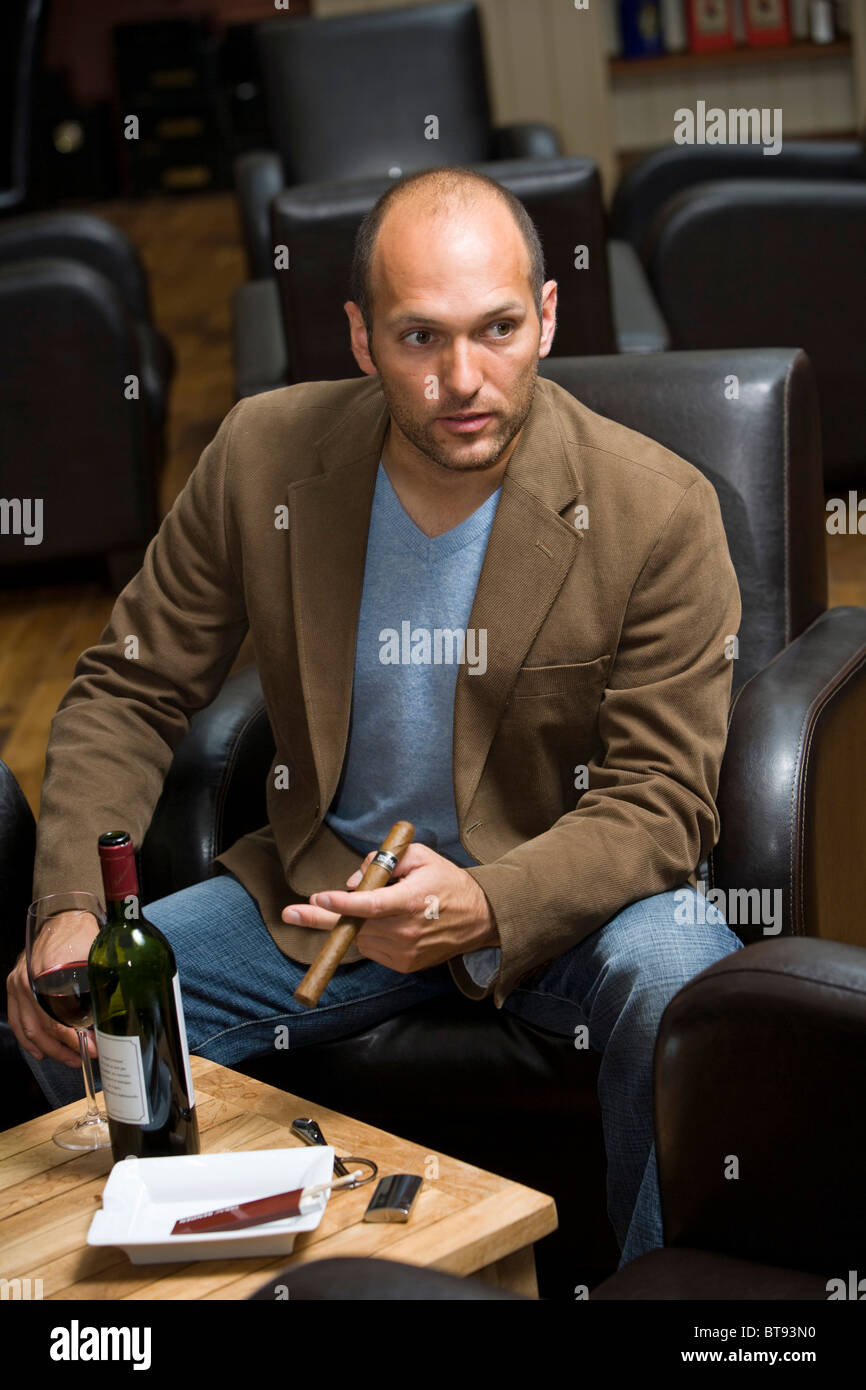 Young man drinking wine and smoking a cigarette Stock Photo - Alamy