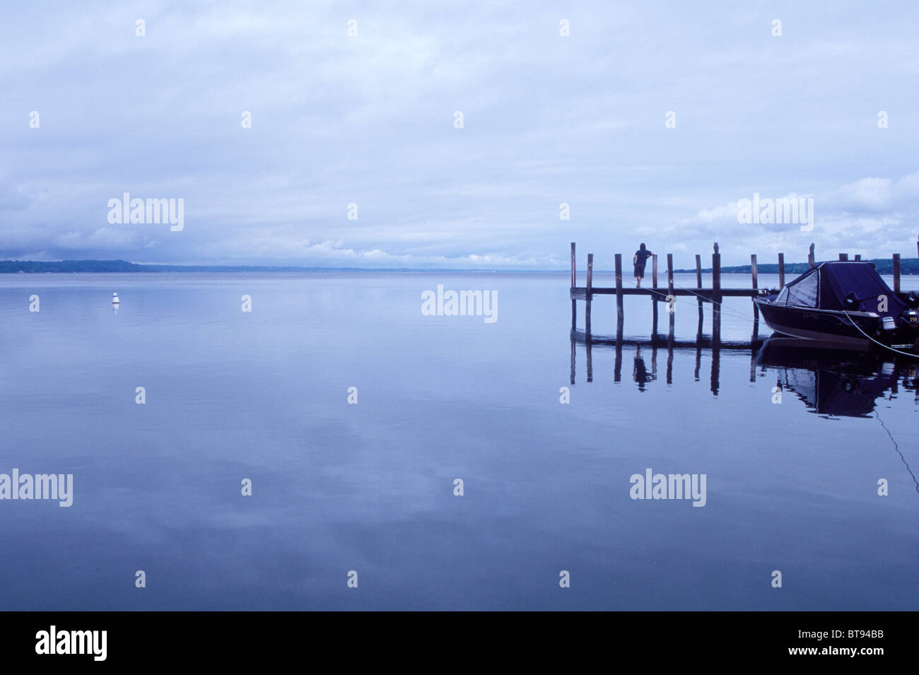 Man relaxing on dock, Cayuga Lake, The Finger Lakes, New York, USA ...