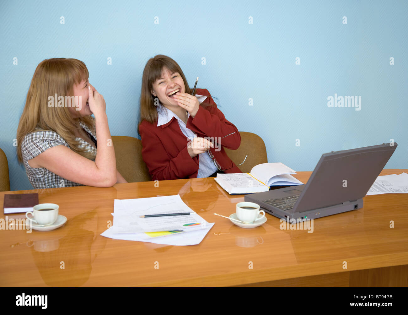 Young girls laugh sitting at a table Stock Photo - Alamy