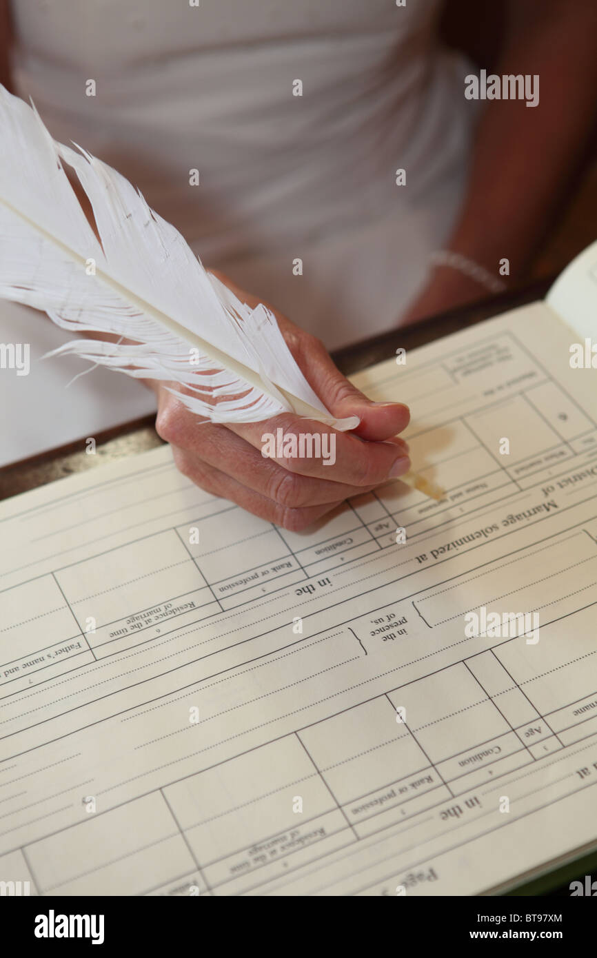Bride signing the register with a feather pen Stock Photo - Alamy