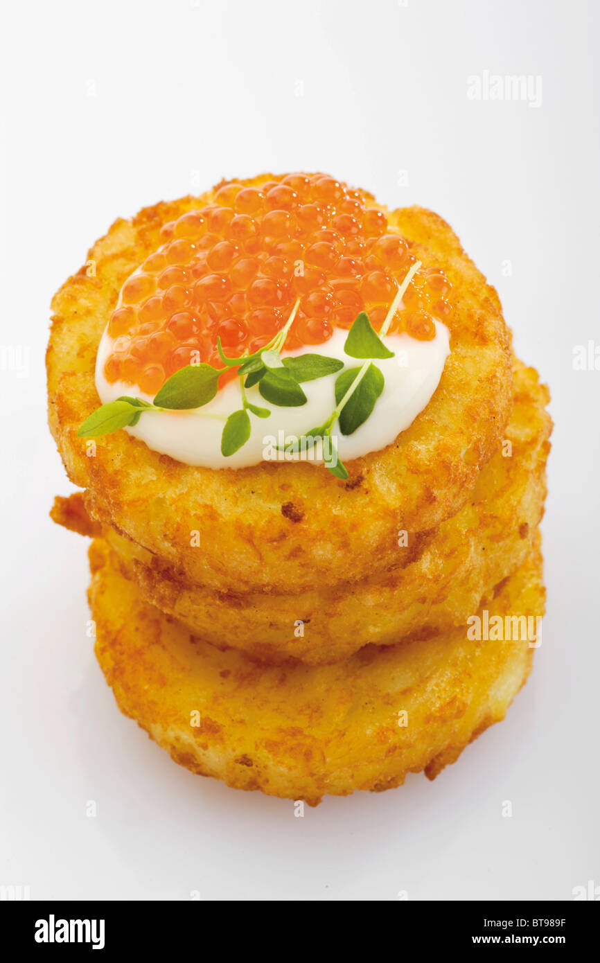 Stack of potato patties with fresh cream and trout caviar Stock Photo ...