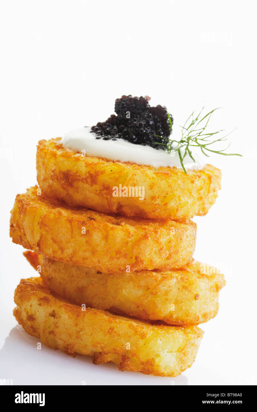 Stack of potato patties with fresh cream and trout caviar Stock Photo ...