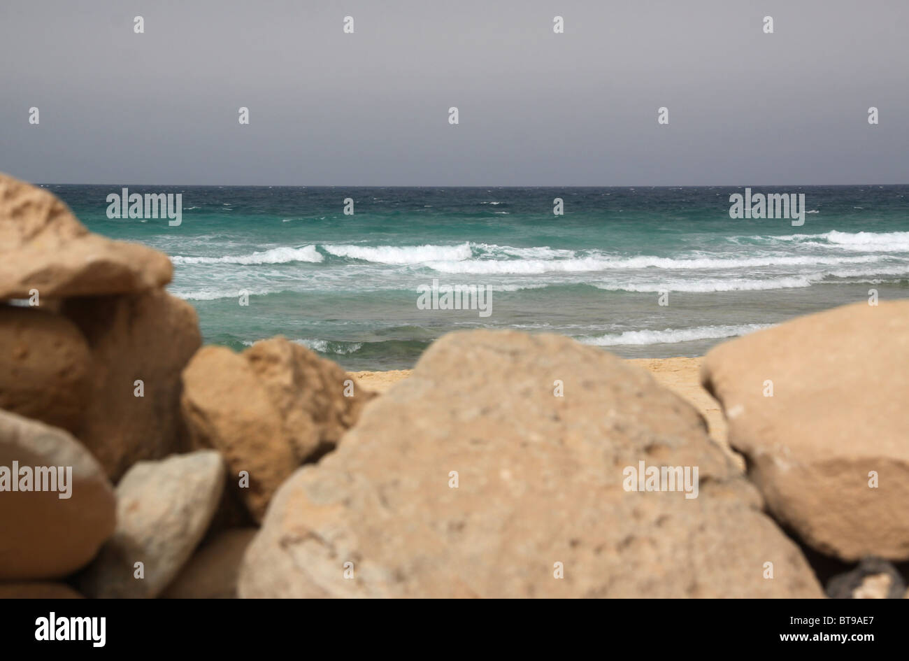 Stone windbreak on sunny beach Stock Photo - Alamy
