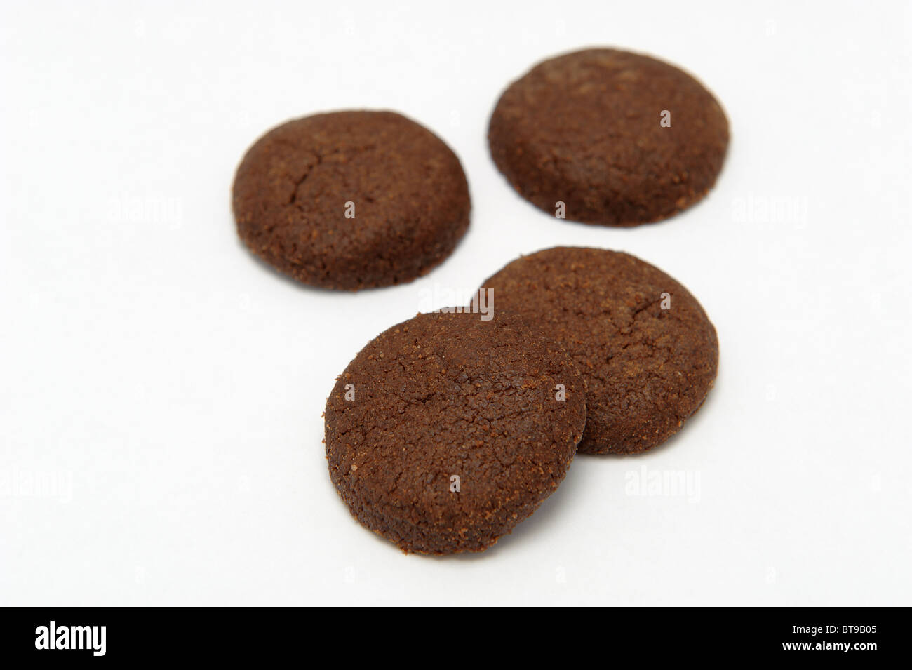 Close up shot of four round chocolate cookies isolated on white ...