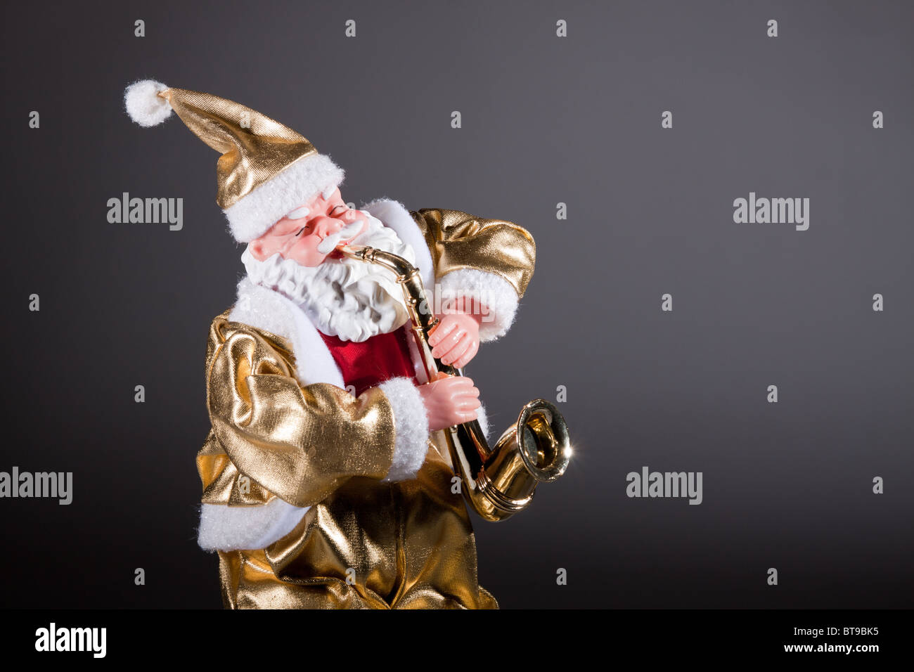 santa claus figure dressed in gold plays the saxophone Stock Photo - Alamy
