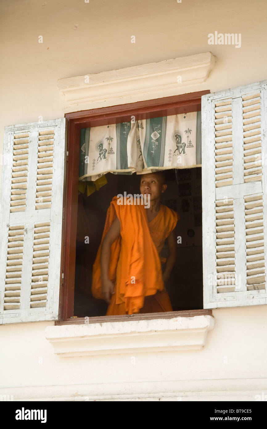 A student ,dressed in the orange robes of a Buddhist monk, looks from ...