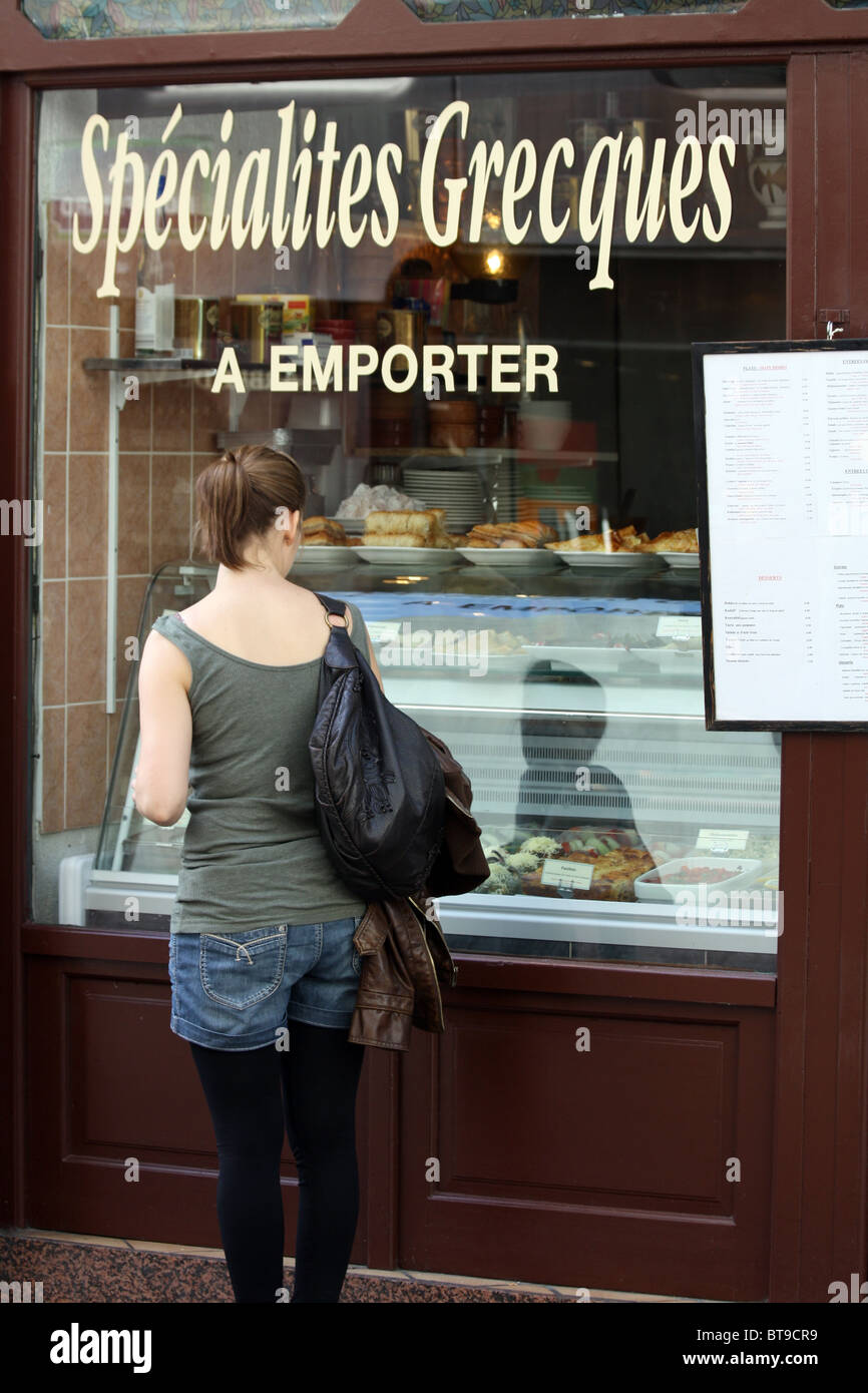 Woman looking through a window of a Greek Food shop in Paris, France ...