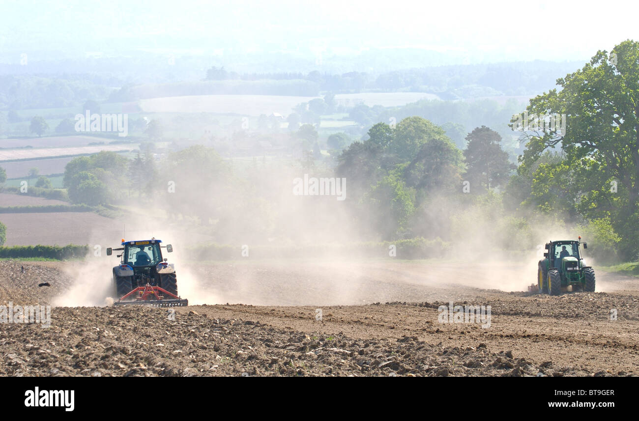 Tractor working on dry land in Sussex pulverising the soil and creating ...