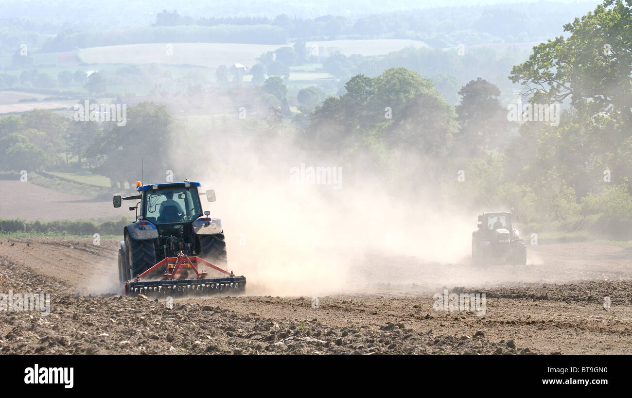 Tractor working on dry land in Sussex pulverising the soil and creating ...