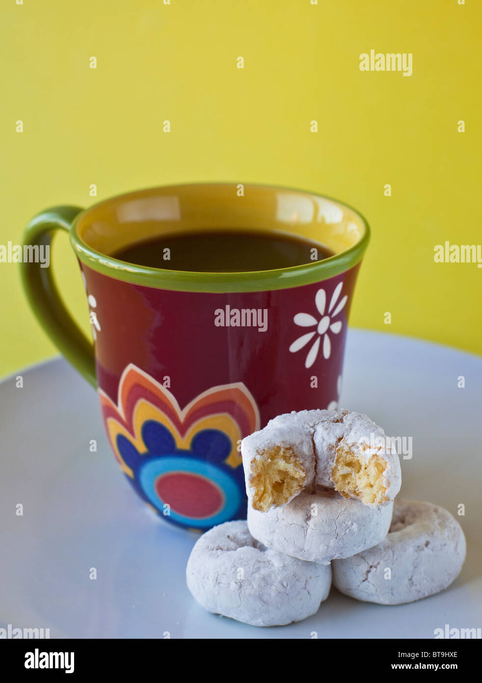 coffee with donuts on plate with yellow background Stock Photo - Alamy