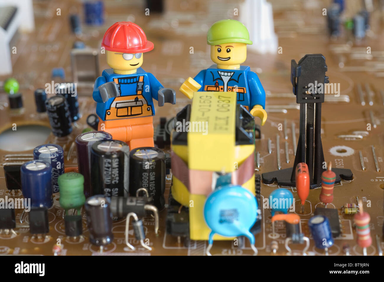 Lego engineers discussing their work on an electronic circuit board ...