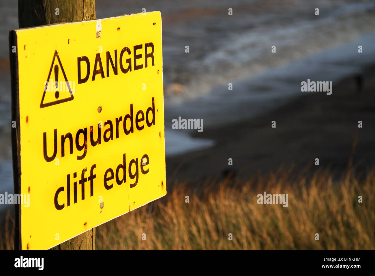 Danger warning sign on unguarded cliff edge at Skipsea in north ...