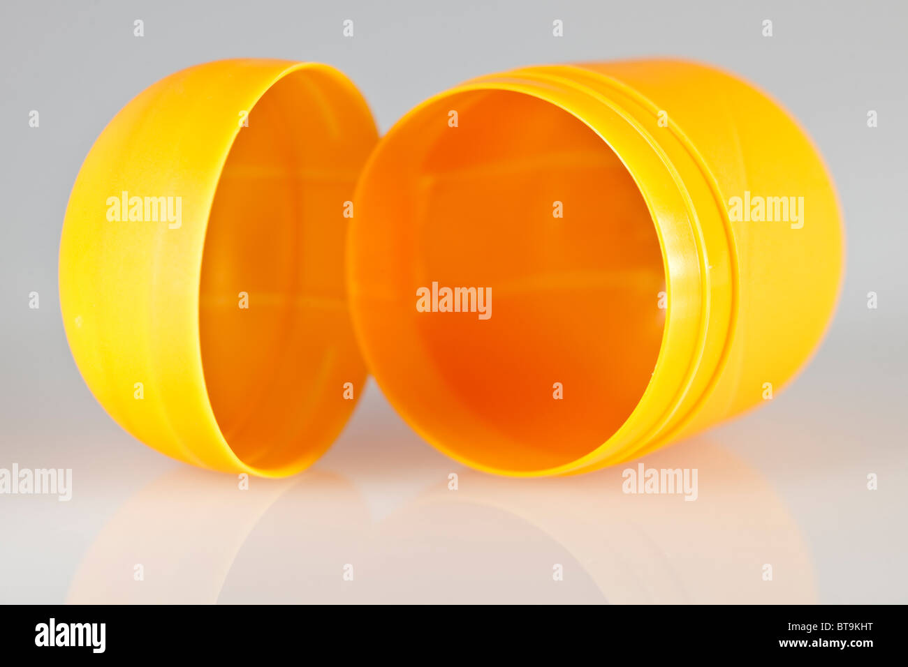 Small yellow plastic flip top oval container Stock Photo - Alamy