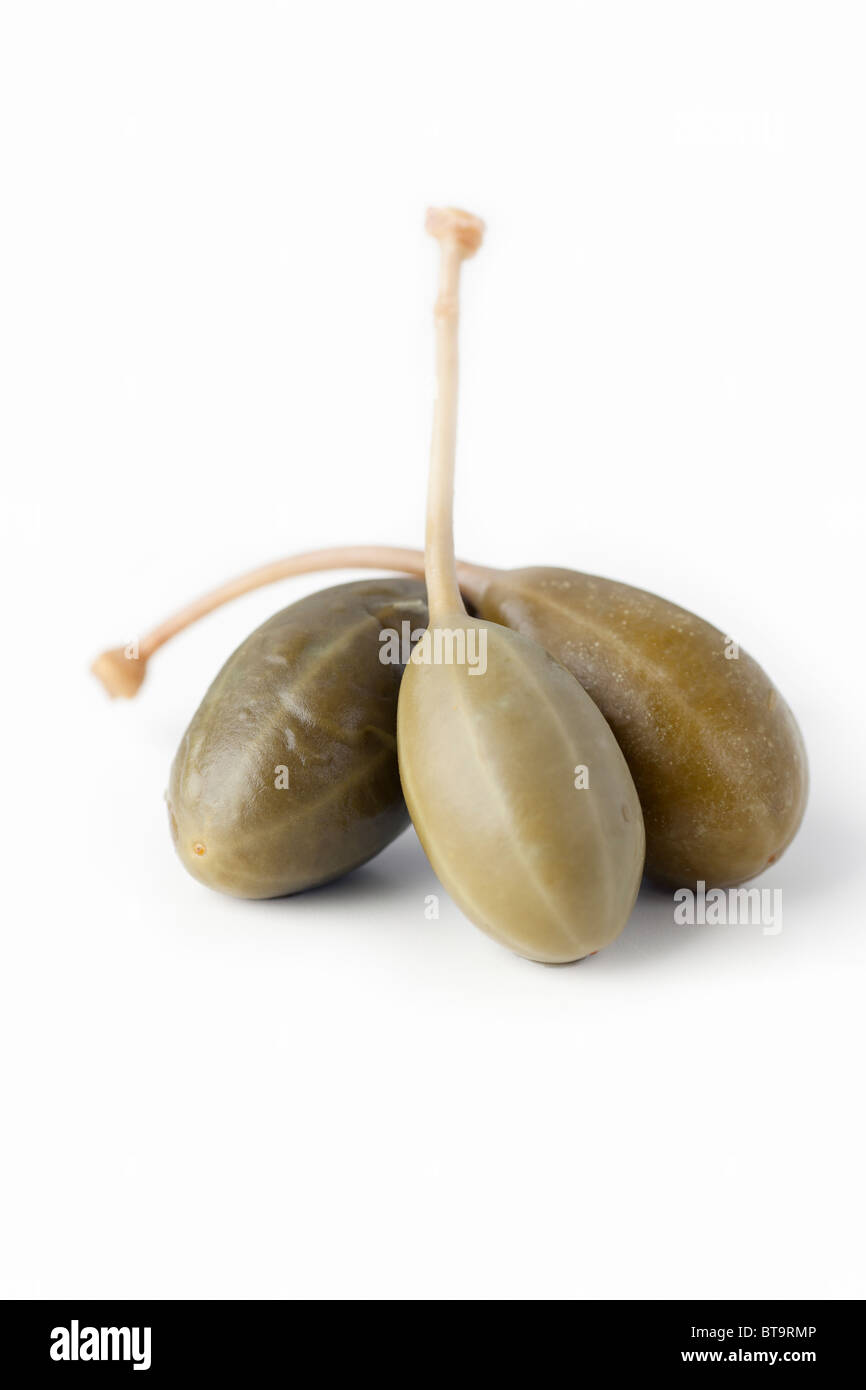 Three large capers isolated on white background with vertical ...