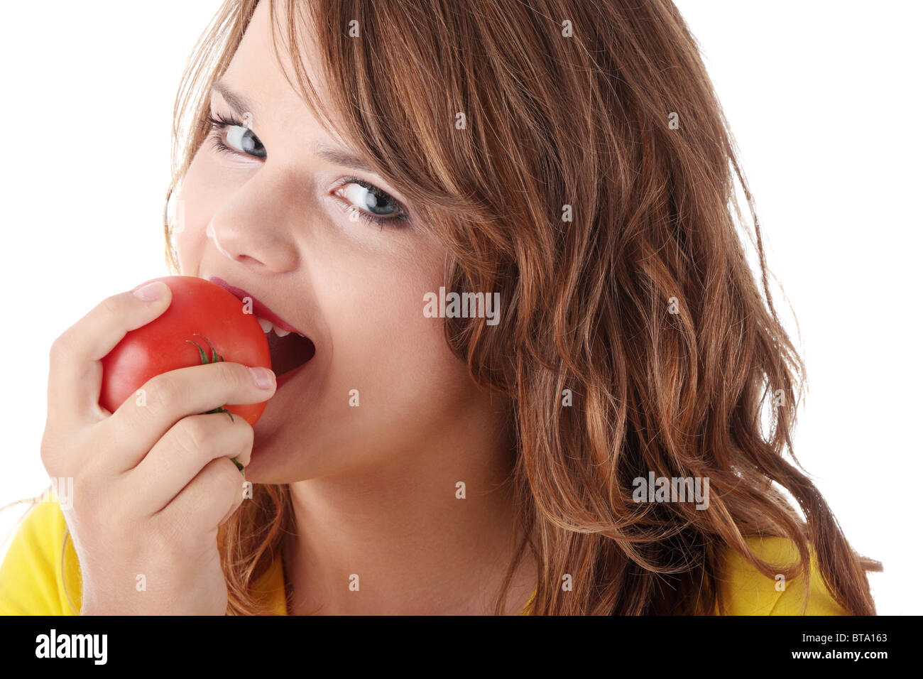 Young woman eating tomato isolated on white background Stock Photo - Alamy