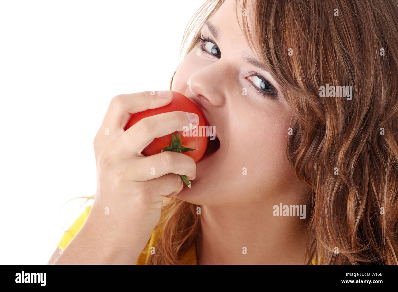 Young woman eating tomato isolated on white background Stock Photo - Alamy