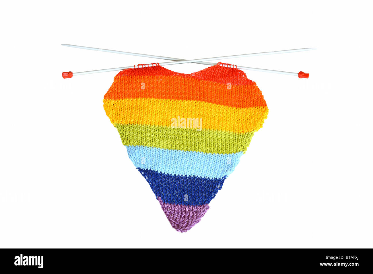 Multi-coloured knitting in the form of heart on a white background ...