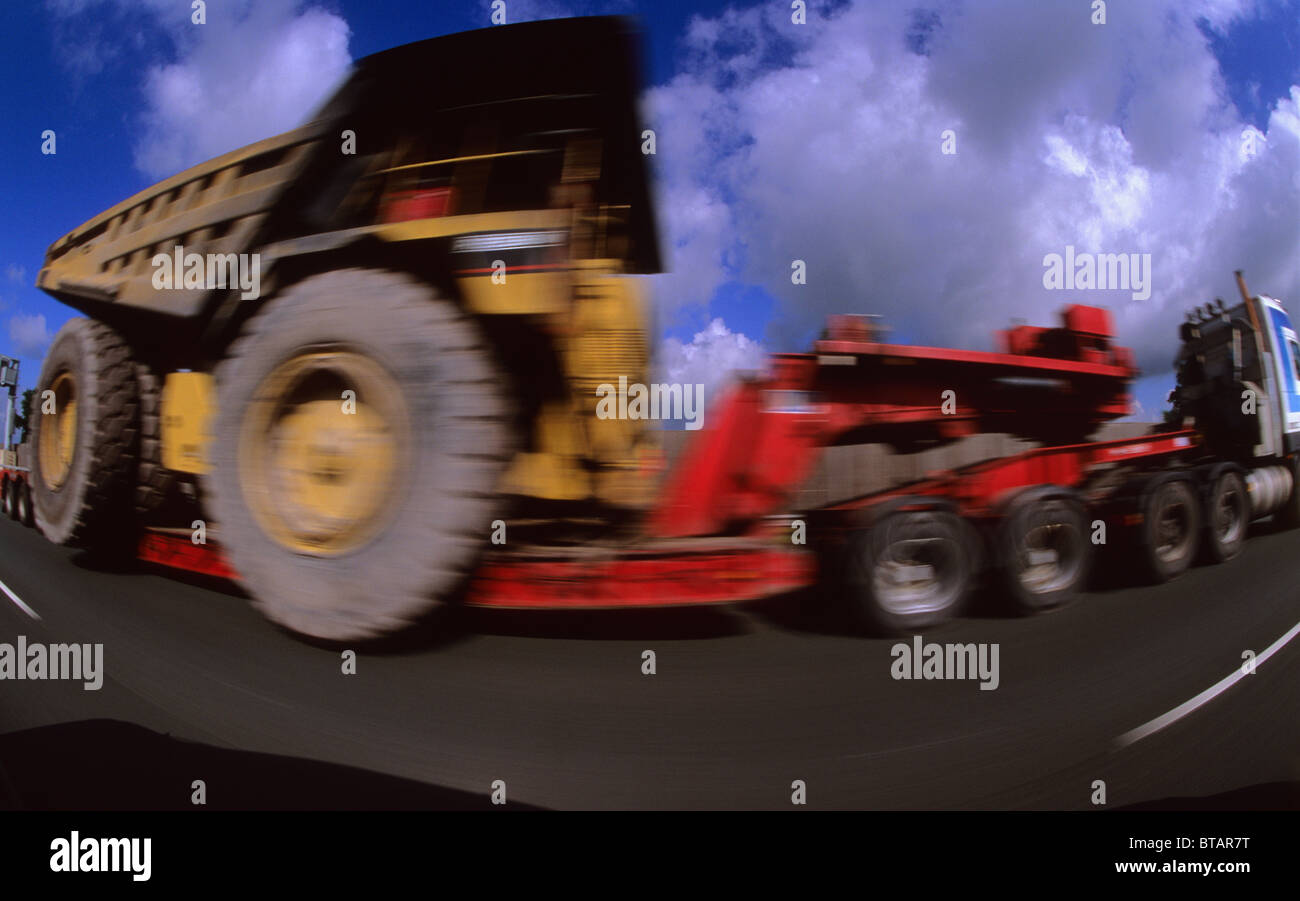 low loader lorry carrying heavy giant truck on trailer traveling on the ...