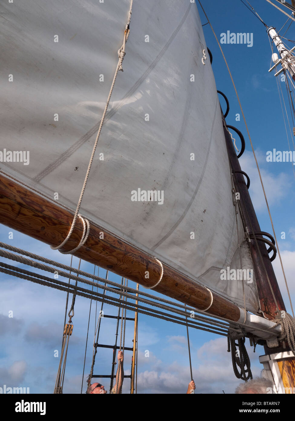 Passengers helping to hoist the sail on the Sailing Ship the Schooner ...