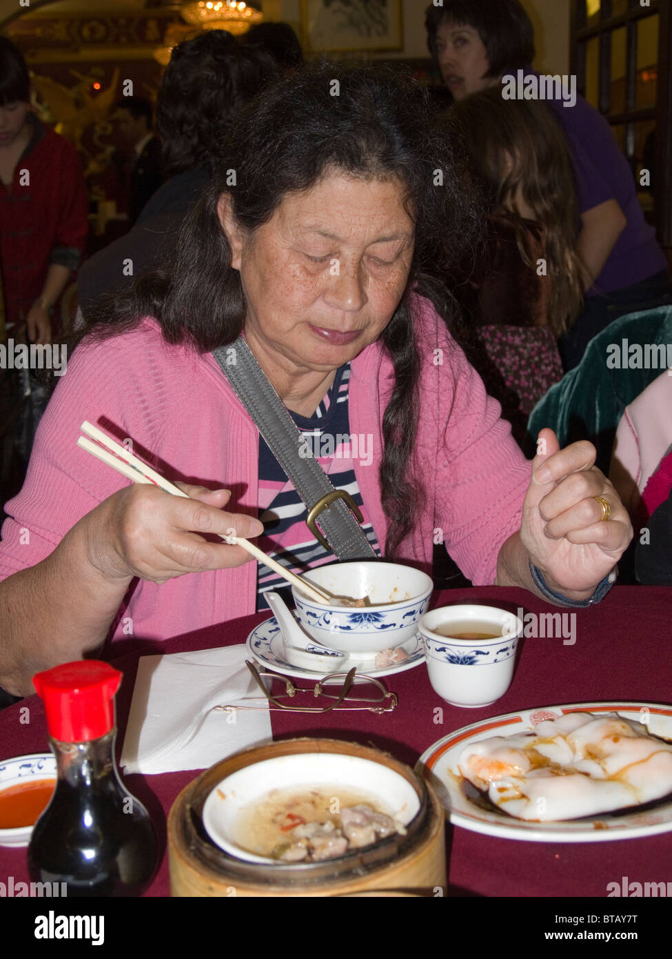 Woman eating dim sum in a Chinese restaurant, Chinatown, London ...