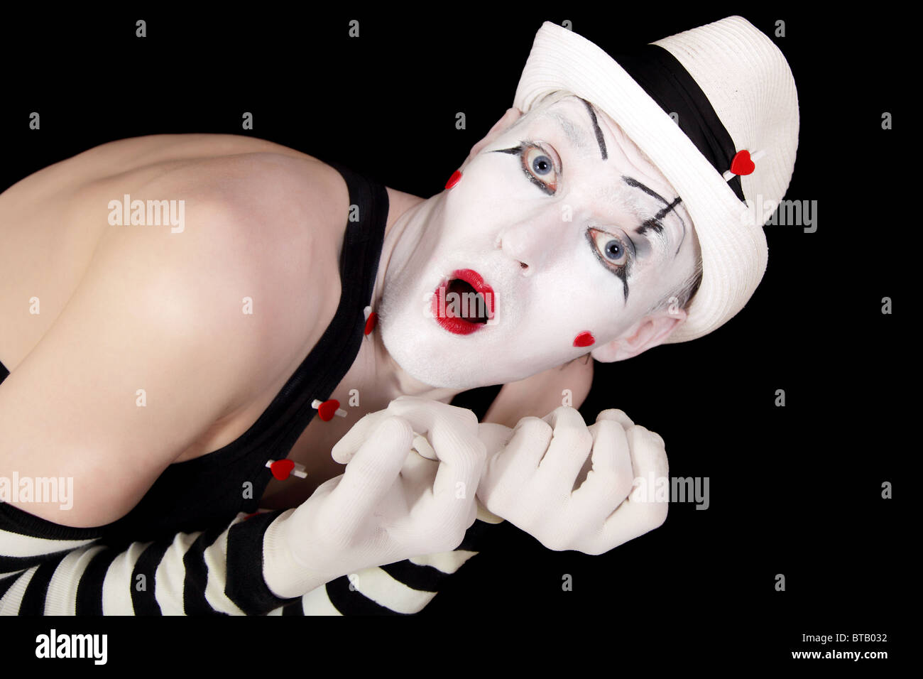 mime in striped gloves and white hat isolated on black background ...