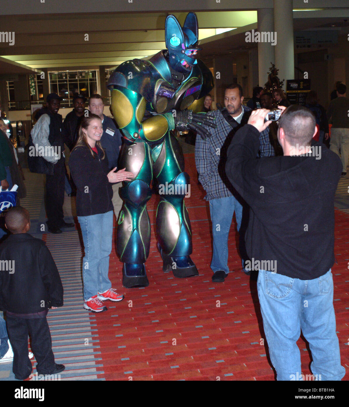 Man takes a picture of a robot walking down the hallway at the ...