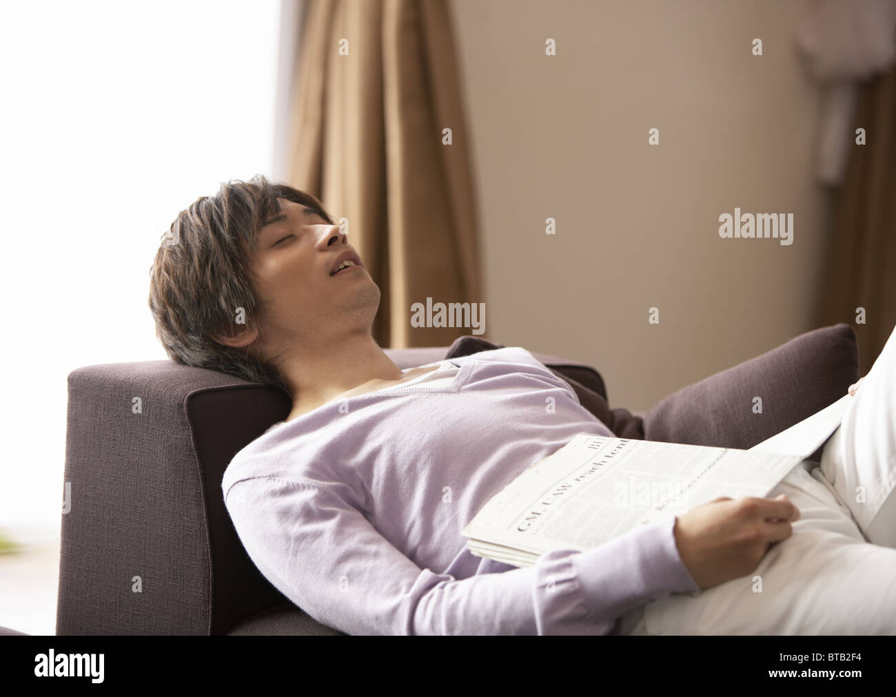 Young man taking a nap on sofa Stock Photo - Alamy
