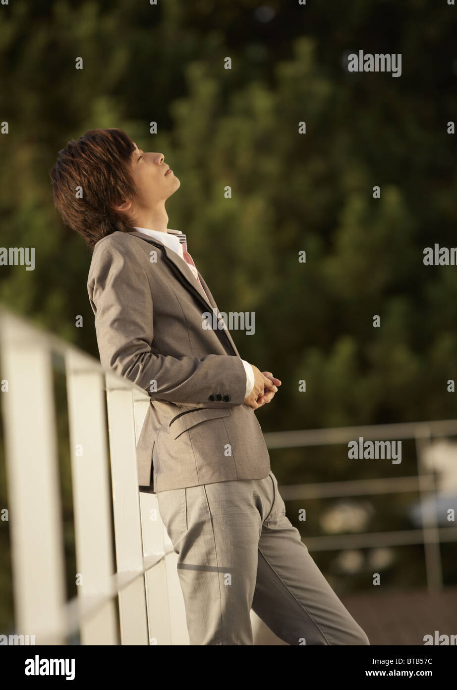Young man standing on terrace Stock Photo - Alamy