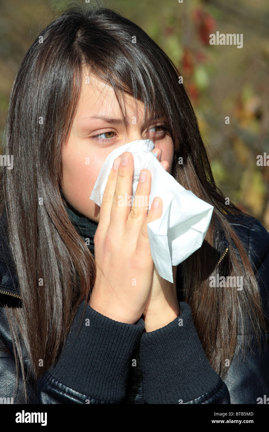 Teen Girl blowing her nose outdoors in late autumn Stock Photo - Alamy