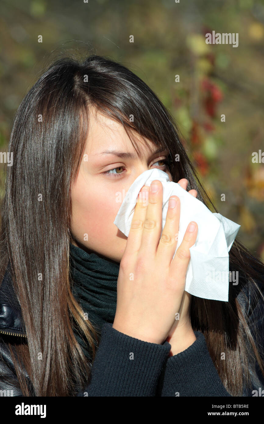 Teen Girl blowing her nose outdoors in late autumn Stock Photo - Alamy