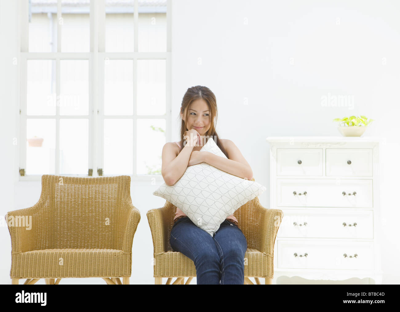 Young woman sitting in chair Stock Photo - Alamy