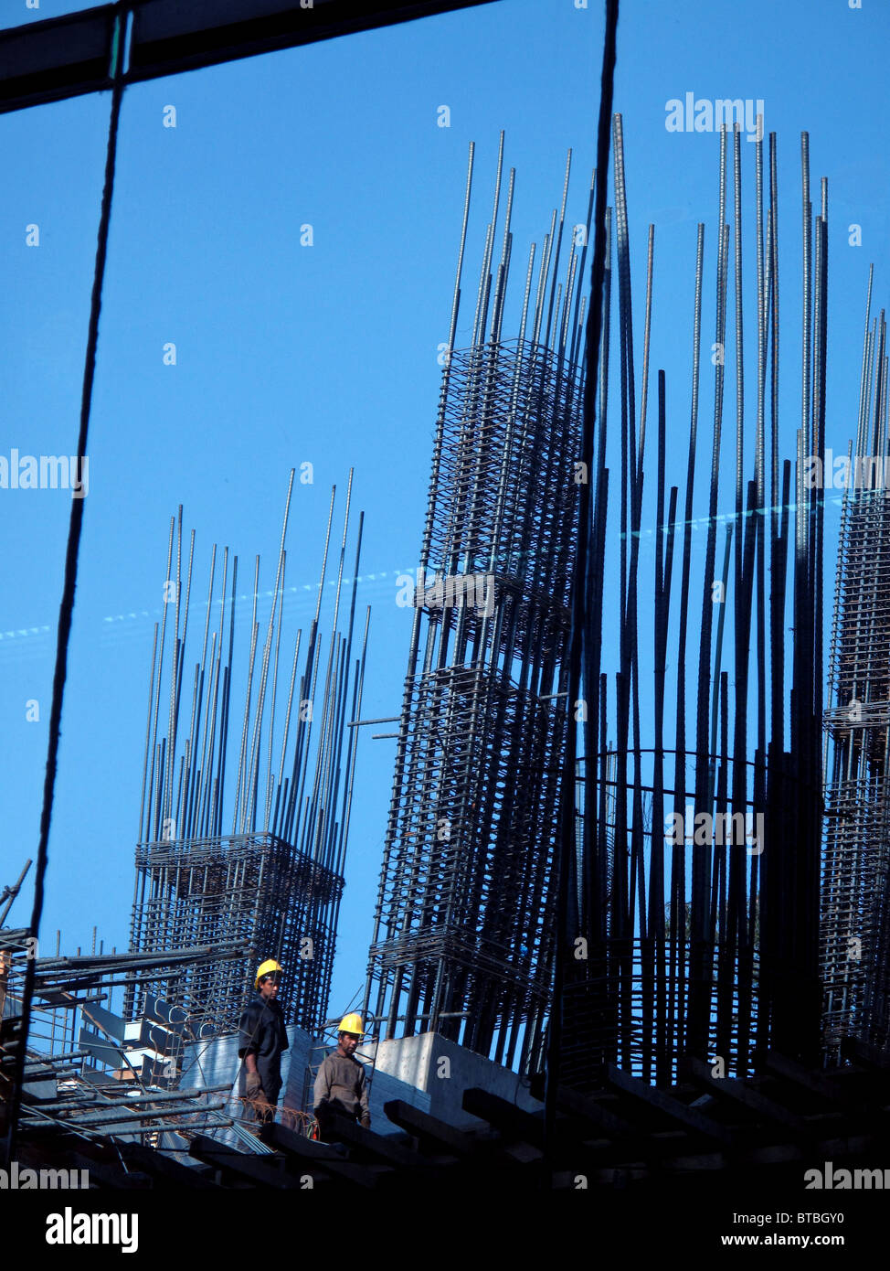 Workers and steel structures of a building construction are reflected ...