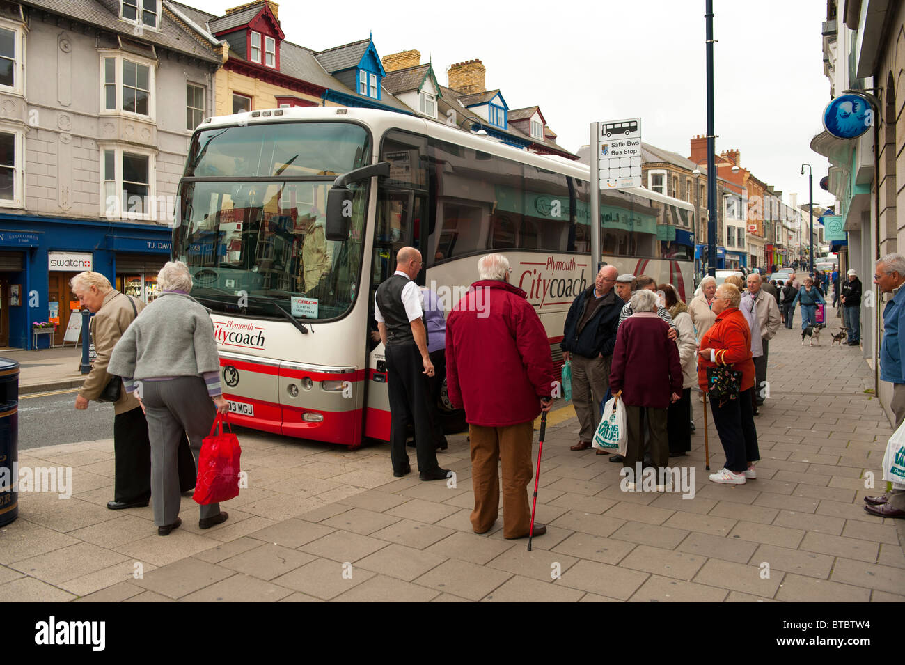 A group of senior tourists about to board a tour coach bus Aberystwyth ...