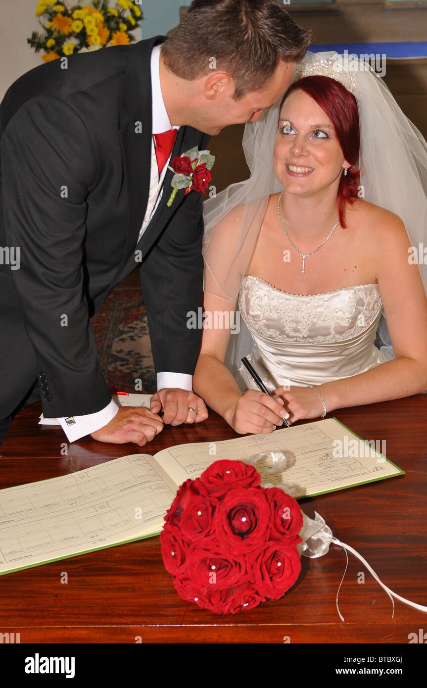 bride and groom signing register smiling Stock Photo - Alamy