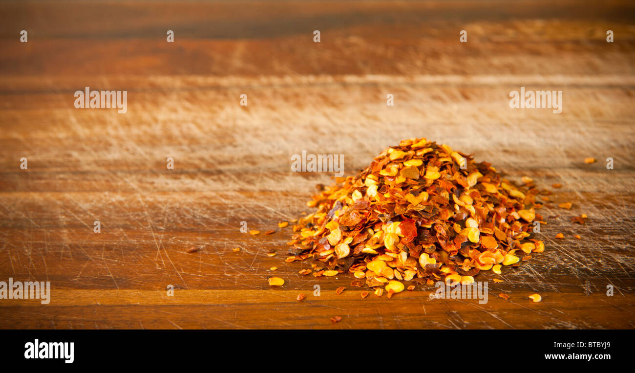 Pile of red chilli seeds on a timber board Stock Photo - Alamy