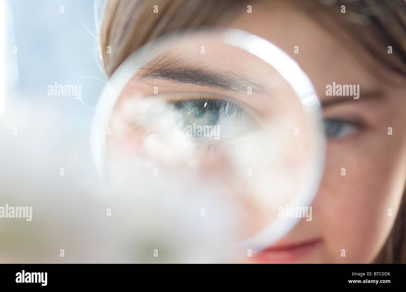 young female girl looking through magnifying glass Stock Photo - Alamy