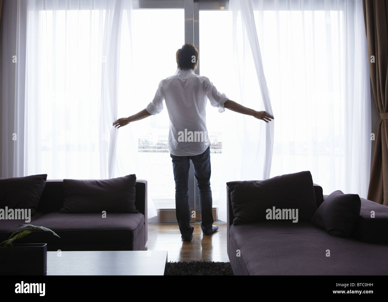 Young man by the window Stock Photo - Alamy