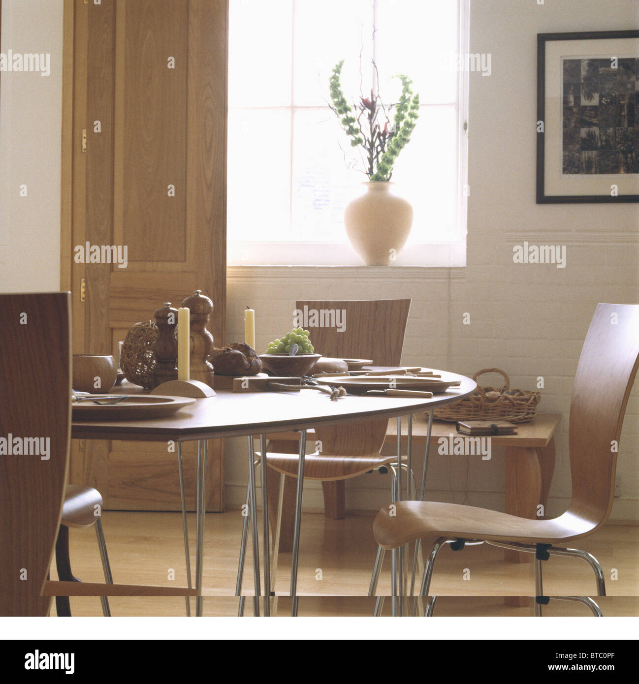 Wood+steel chairs and table in modern neutral dining room Stock Photo ...