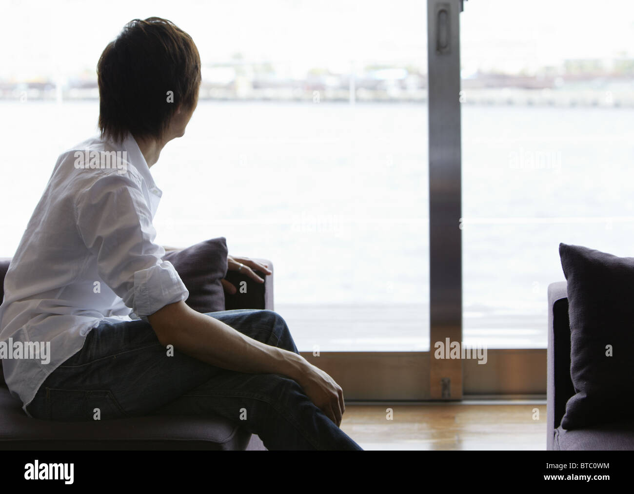 Young man looking outside Stock Photo - Alamy